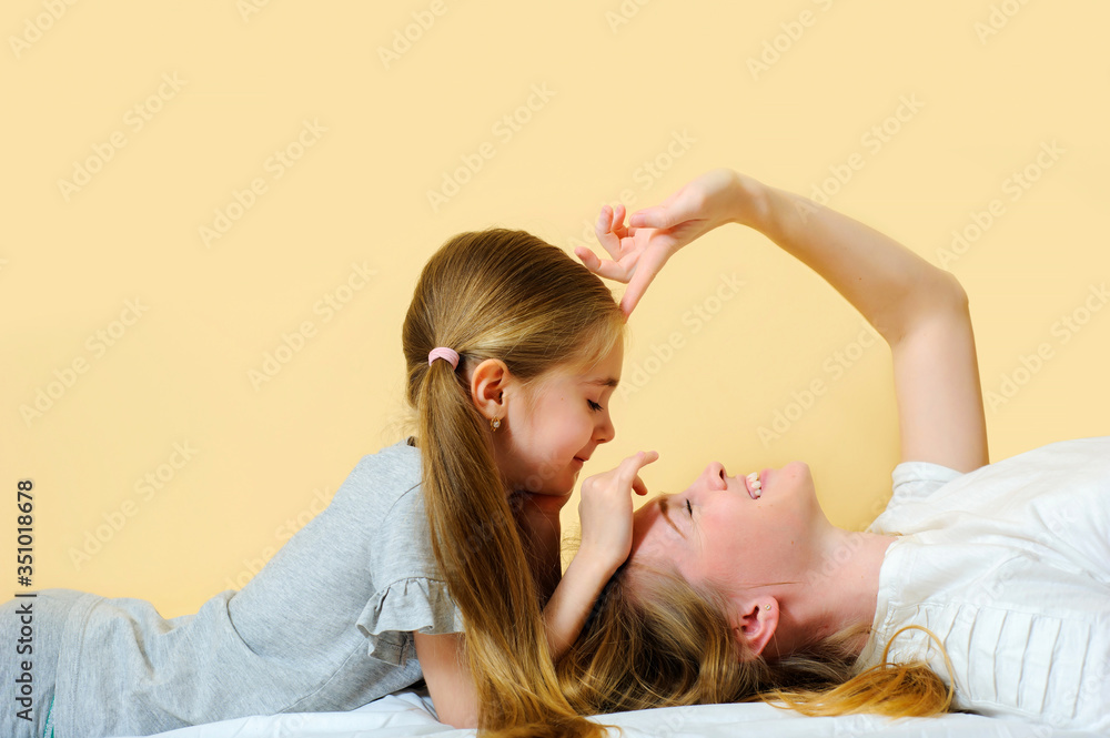 Mom And Daughter Are Lying On The Floor And Looking At Each Other