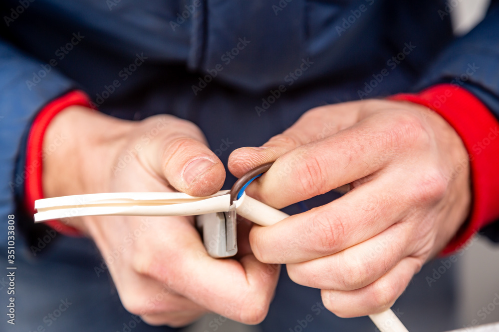 Cutting cable insulation with a segmented knife. White cable, yellow ...