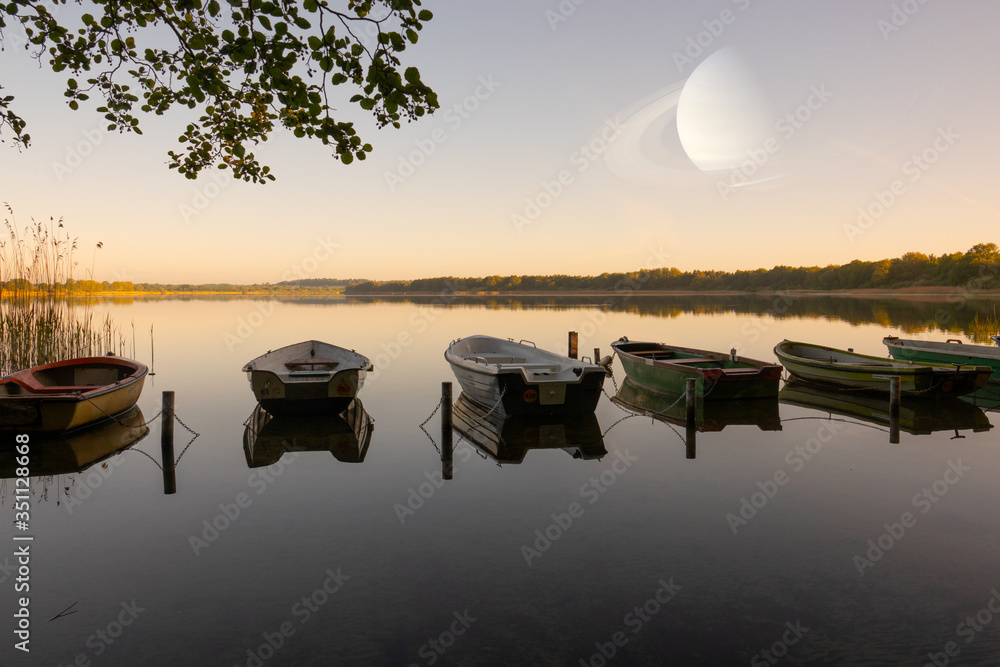 some Rowing boats lie next to each other on the shore of a lake in ...