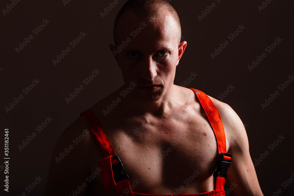 Sexy builder on a black background. Builder with a helmet on his head ...
