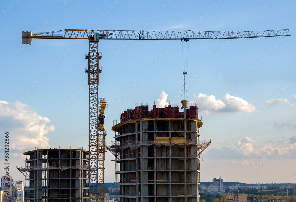 Tower crane in action on blue sky background. Preparing to pour a ...