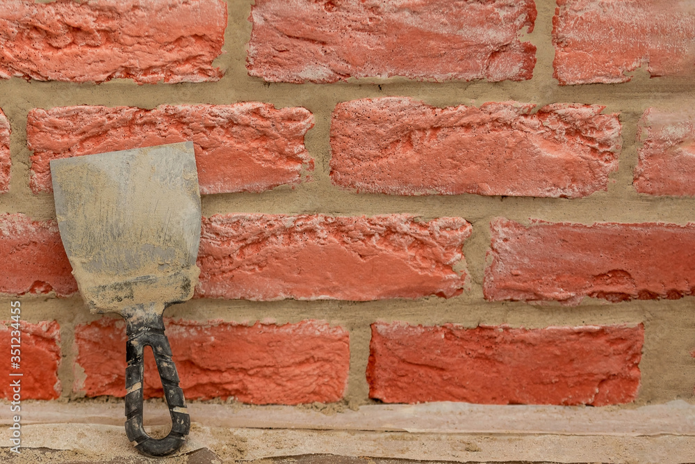 The putty knife with traces of concrete mortar is on the background of ...