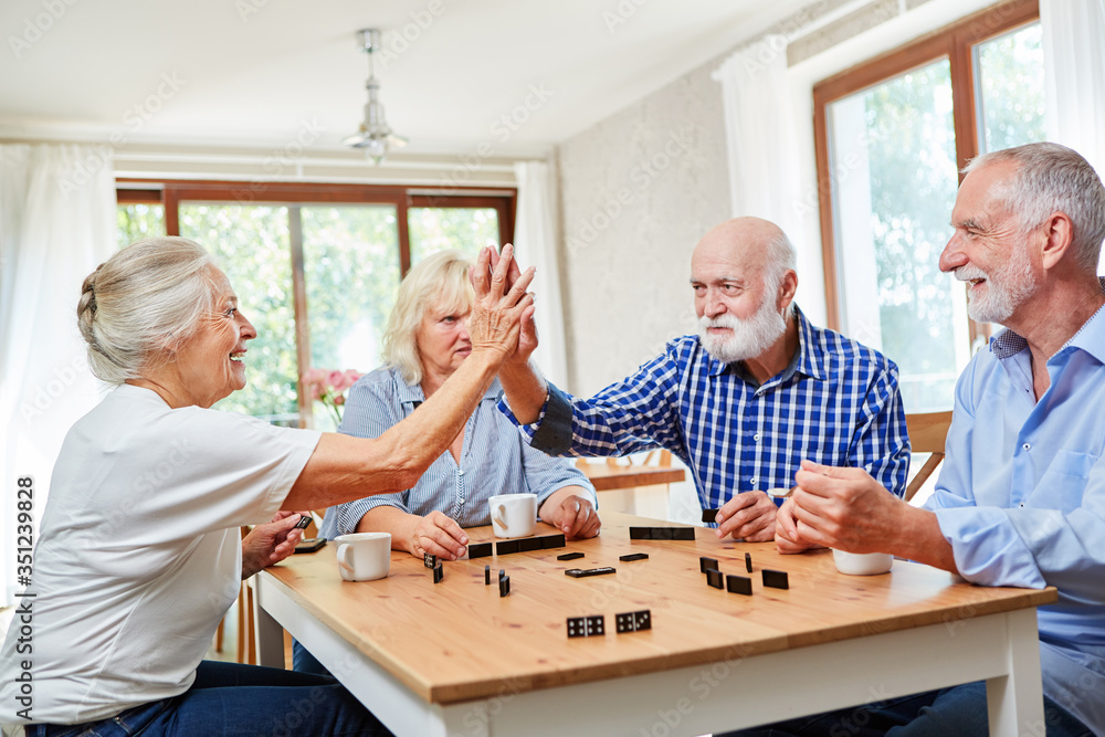 Seniors give themselves a high five at Domino Stock Photo | Adobe Stock