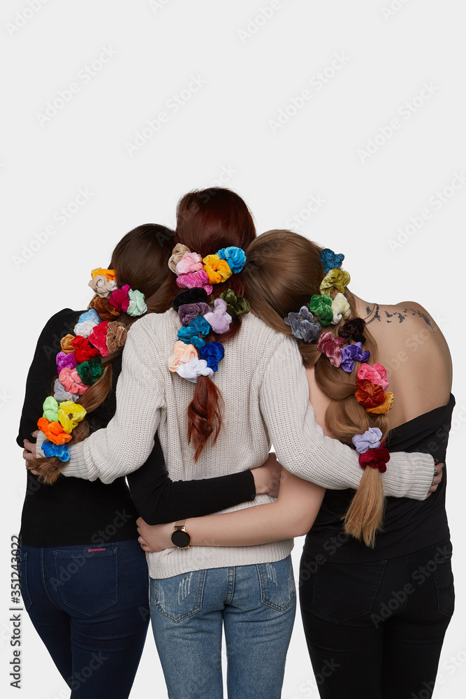 Back view of three girls with colorful velvet scrunchies in their long ...