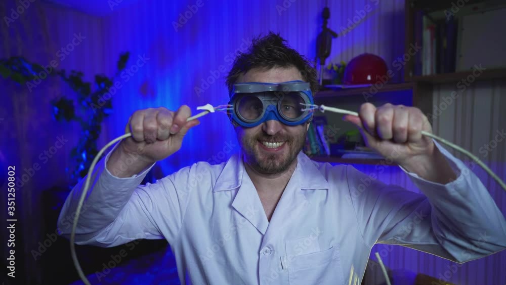 Crazy doctor connects two electrical wires. Hairy Computer nerd with ...