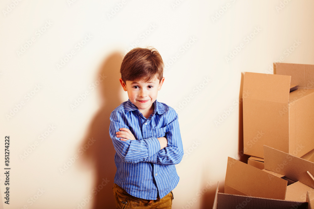 little cute boy in empty room, move to new house. home alone among ...