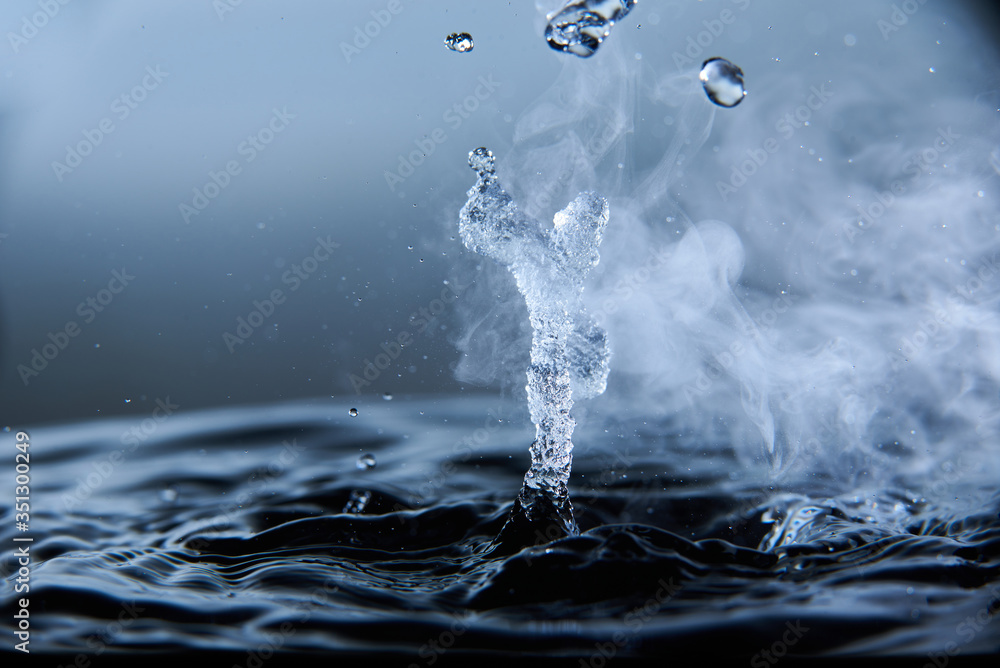 Boiling water splash with steam on dark blue background closeup Stock ...