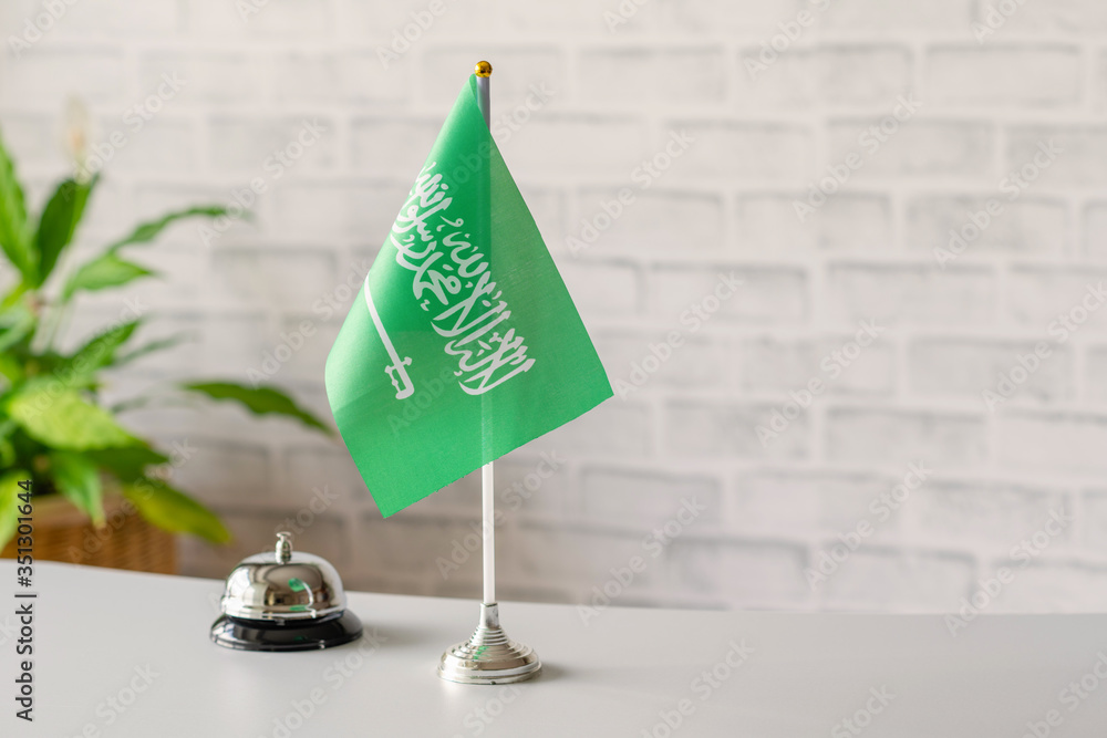 Silver vintage bell with national flag of Saudi Arabia on reception ...