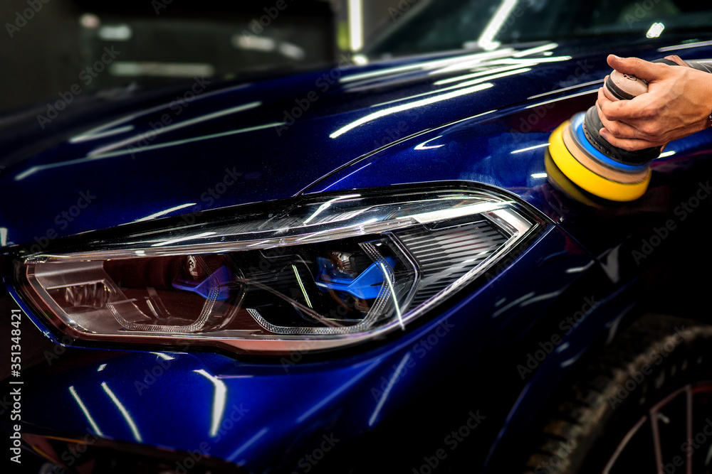 Car detailing shop hands with orbital polisher in auto repair shop ...