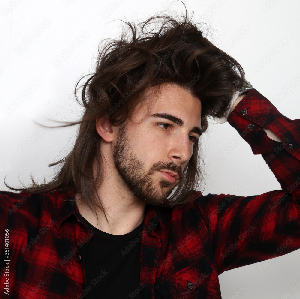 Stylish male model with long hair and beard posing in studio. Modeling ...