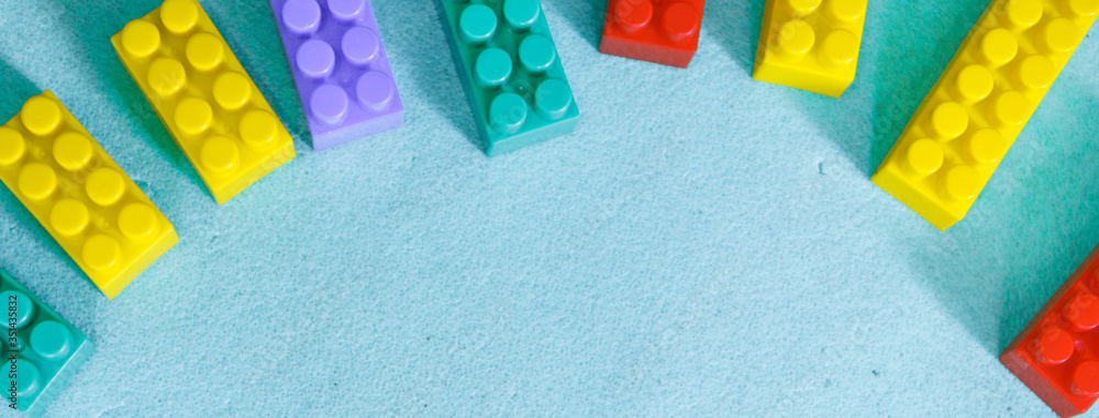 multi-colored parts of constructor. rectangular toys on a blue ...