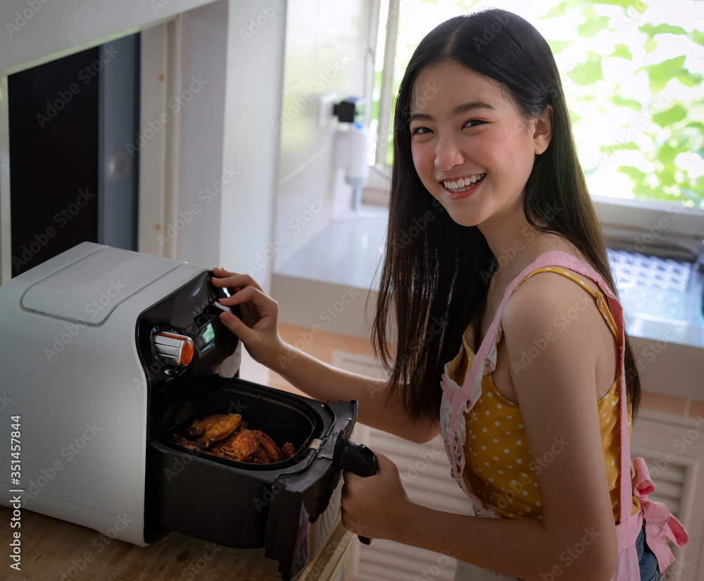 Asian girl cooking a fried chicken by Air Fryer machine Stock Photo ...