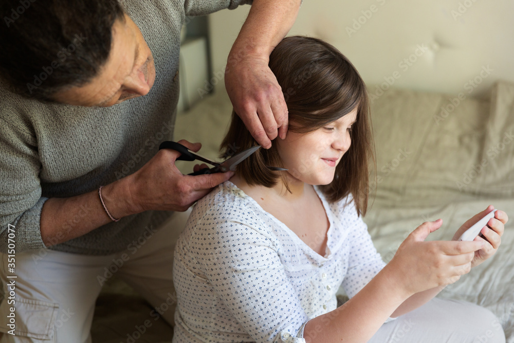 Caucasian dad learns to comb and trim daughter’s hair online. Father ...
