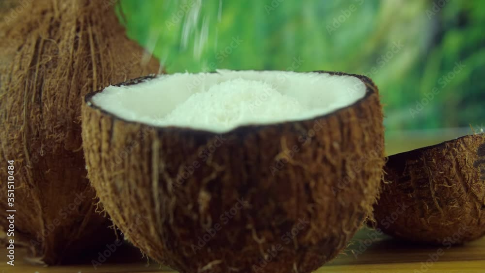 Closeup shot of pouring shredded coconut into a coconut half - healthy ...