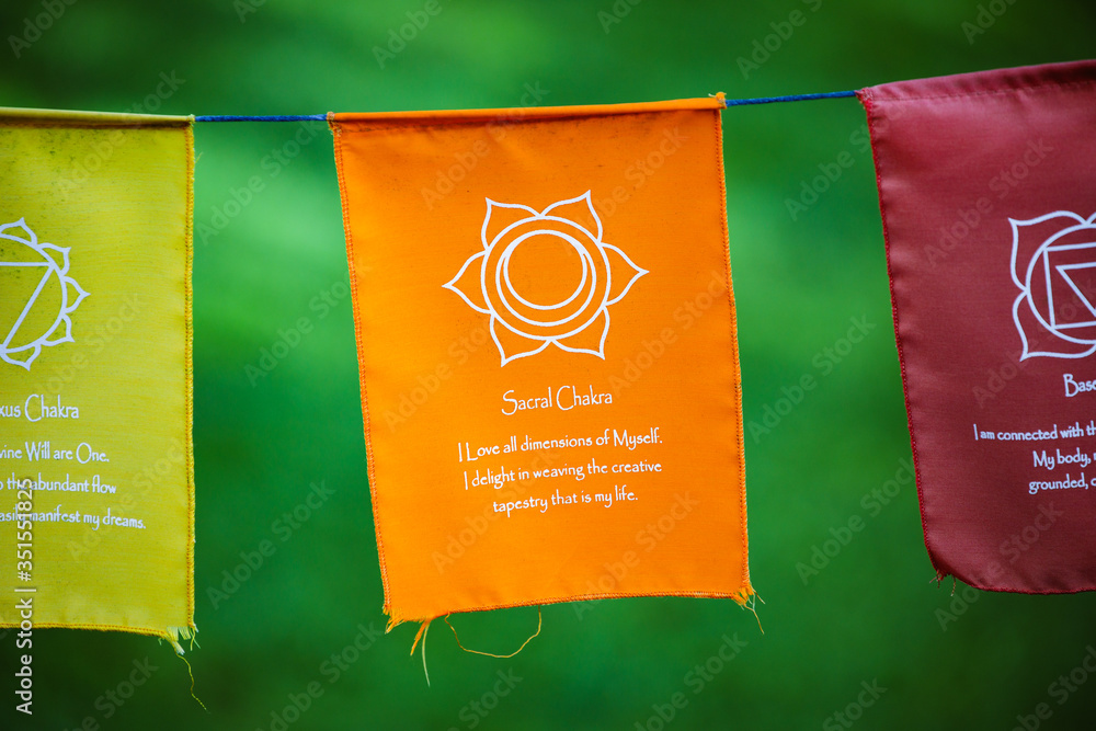Chakra Prayer flags hanging in the breeze. The orange flag is the ...