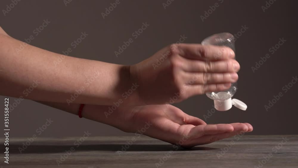 female white hands take a transparent plastic bottle with a liquid gel ...