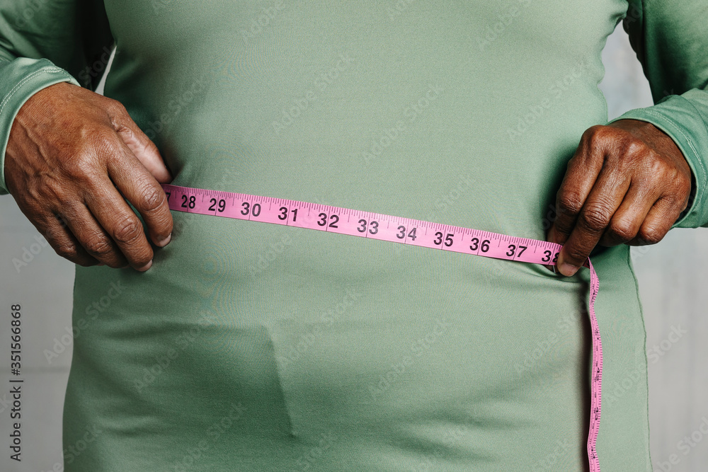 Black woman measuring her tummy Stock Photo | Adobe Stock