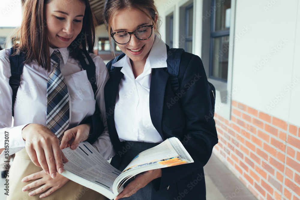 Two female high school students in corridor Stock Photo | Adobe Stock