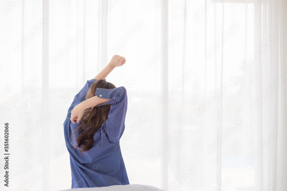 Lazy young Asian woman back side view wake up and sit, stretch lazily ...