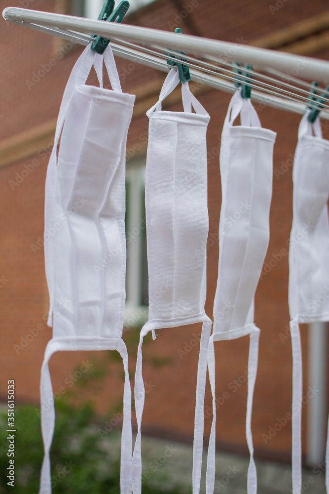 Reusable medical masks hanging on drying equipment for reuse. Masks to ...