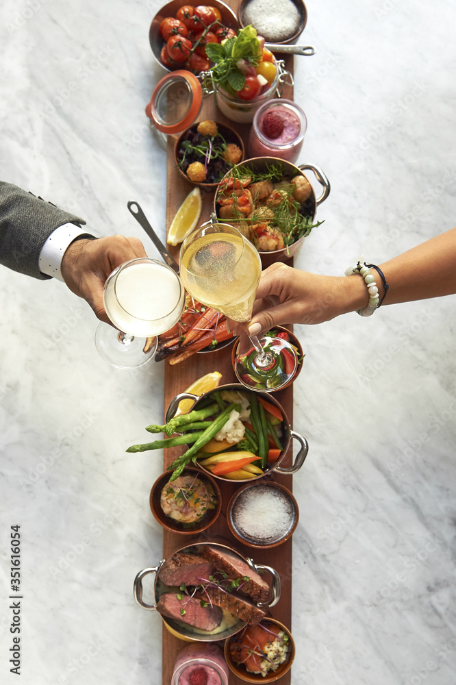 Couple at a restaurant celebrating, from above, top view, served table ...