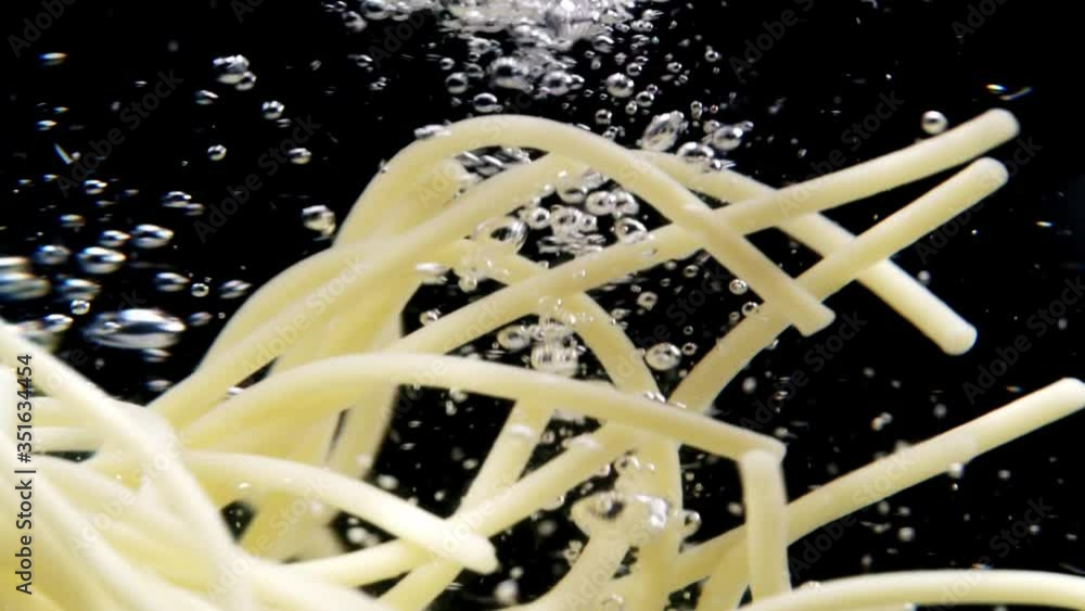 Pasta vortex, spaghetti spinning in the boiling water with bubbles on ...