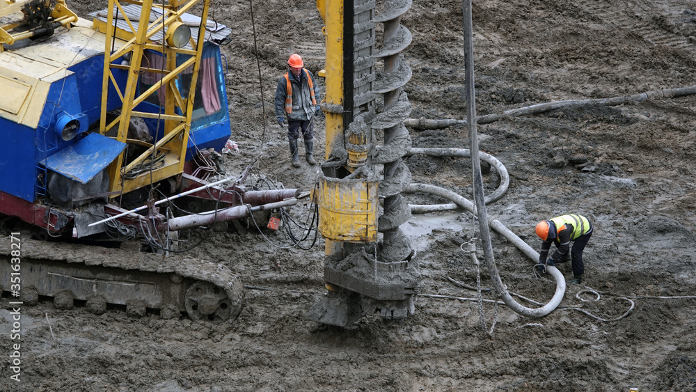 Drilling rig boring the ground pours a hole in the concrete for the ...