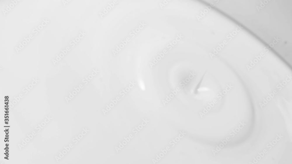 Drop of milk falling into milky, creamy liquid and making ripples in ...