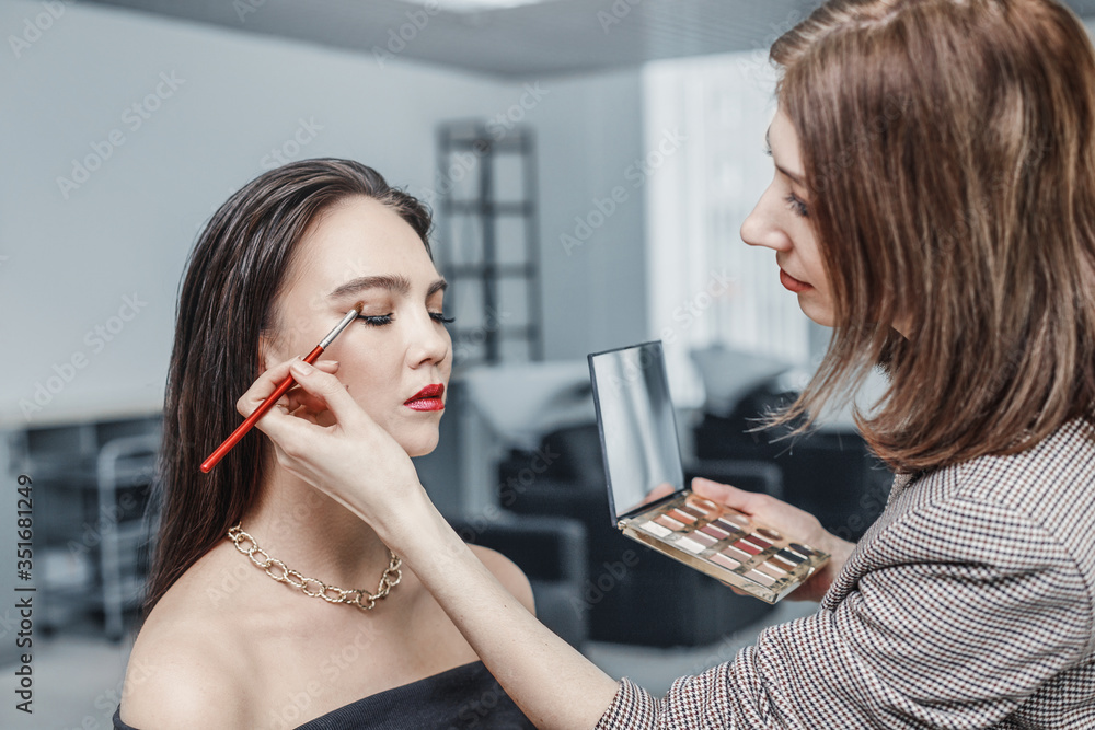 Professional make up artist girl selects a harmonious combination of ...