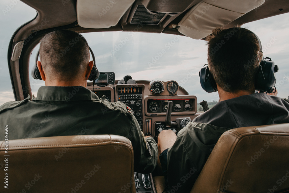 Pilot in cockpit. Aircraft Pilot at work. Rear view of pilots. Rear ...