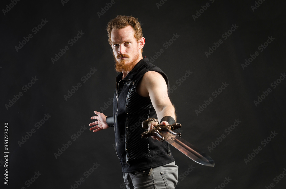 Cosplay portrait of a redhead bearded man holding a two-handed sword ...