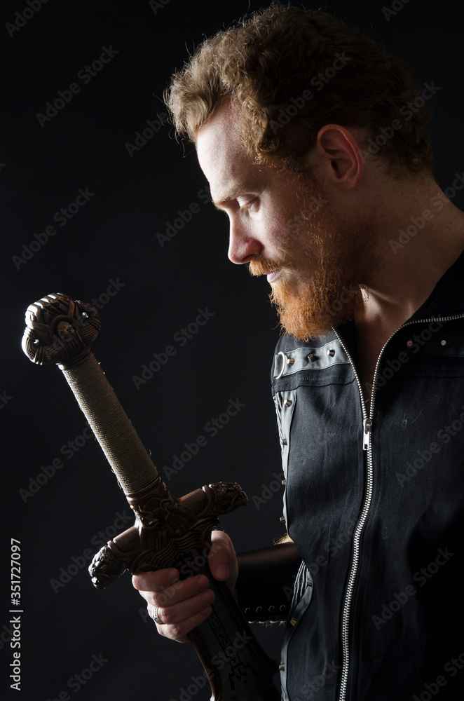 Cosplay portrait of a redhead bearded man holding a two-handed sword ...