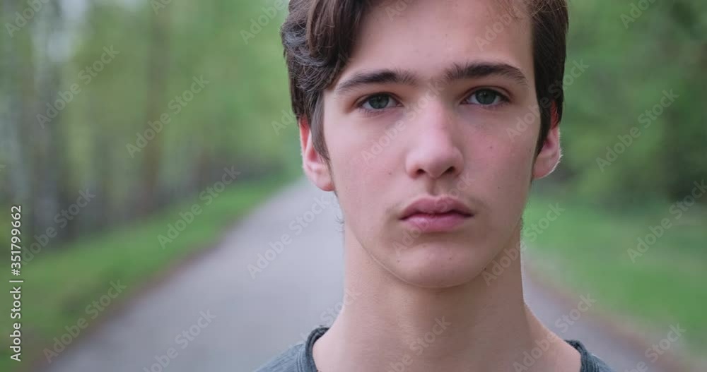 Young sad man looks on the camera. Unhappy alone young teenager ...