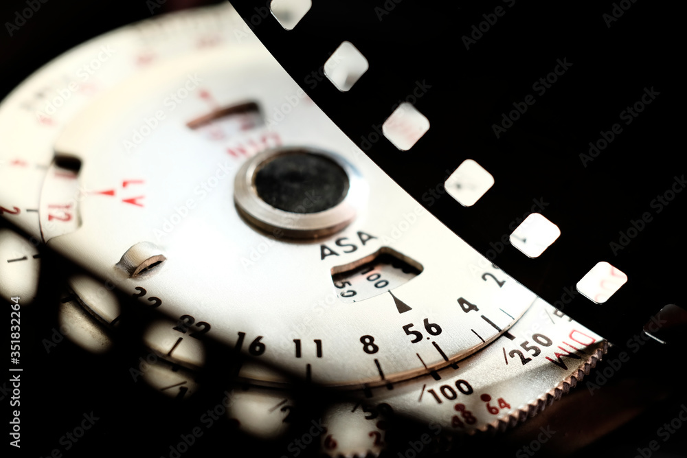 Vintage analog photographic light meter and 35mm negative film. Non ...