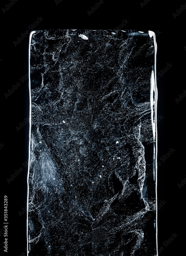 Large rectangle of clear ice with bubbles, against dark background ...