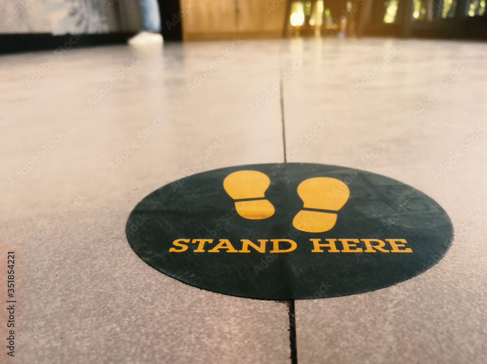 Stand here foot sign or symbol on the floor with the people is waiter ...
