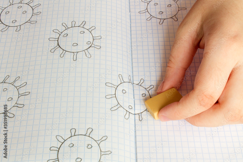 A coronavirus molecule drawn in pencil on a white notebook sheet and a ...