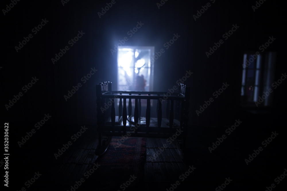 Old creepy eerie baby crib near window in dark room. Scary baby ...
