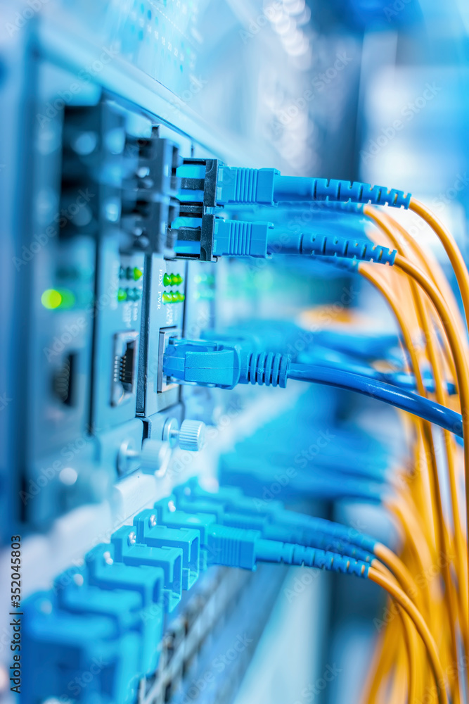 Fiber Optic cables connected to an optic ports and Network cables ...