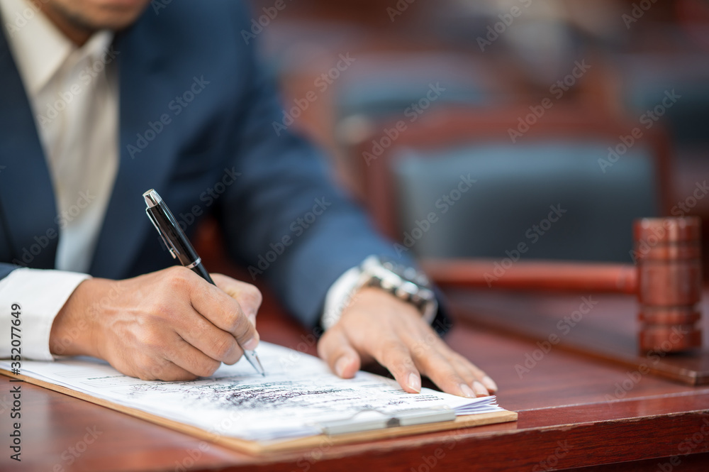 The lawyer is carrying a pen to write a case record in the courtroom ...