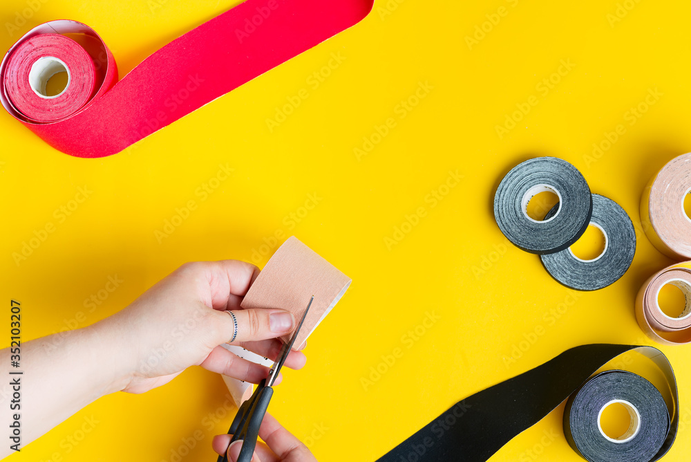 Kinesiology taping treatment process step by step. Female hands are ...