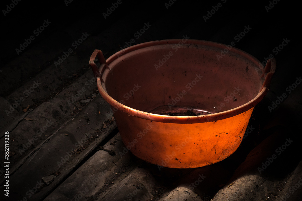 Old worn red bucket standing in a foggy environment on the attic. Red ...