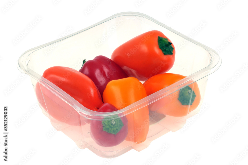 Petits poivrons de différentes couleurs dans une barquette en plastique ...