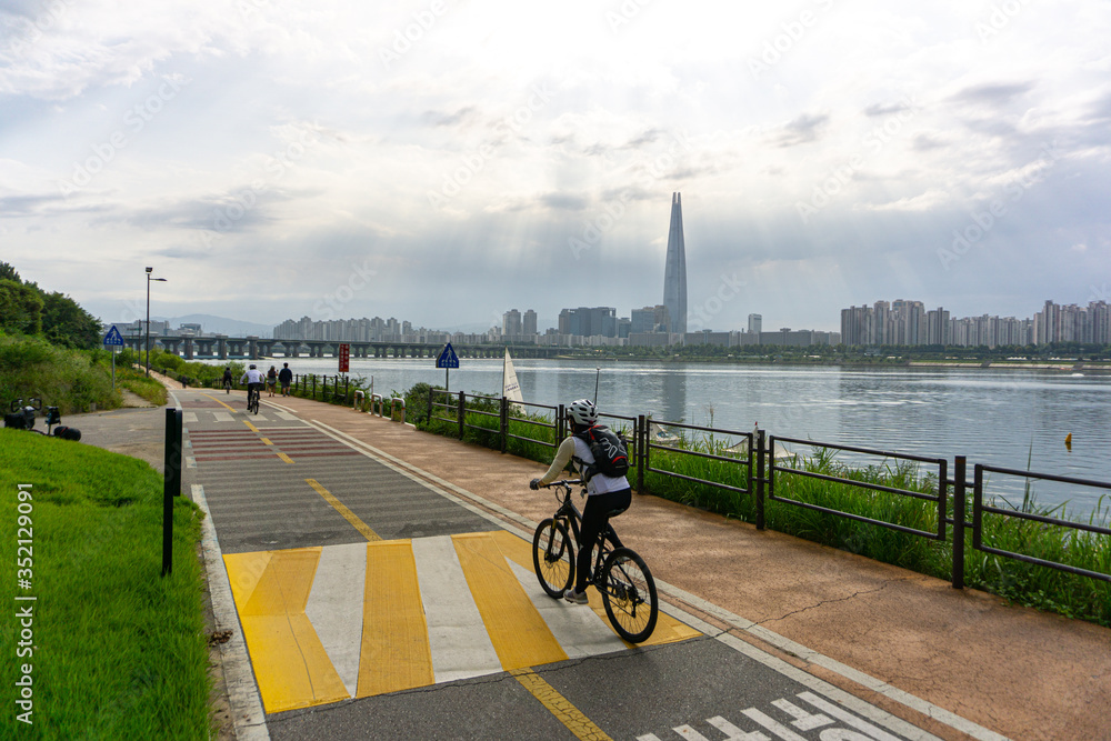 People bike and walk on the Seoul bicycle path along the Han river with ...