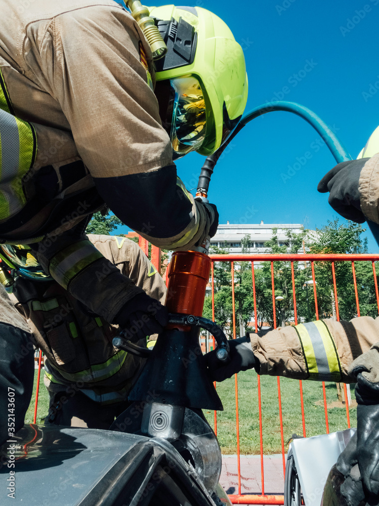 Firefighter using rescue tool in rescue by traffic accident. Salvage ...
