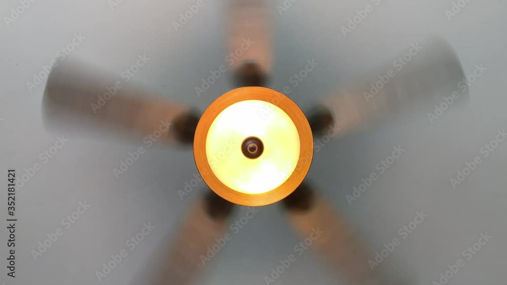 Electric ceiling fan with warm light on turning. Nadir plane of ceiling ...