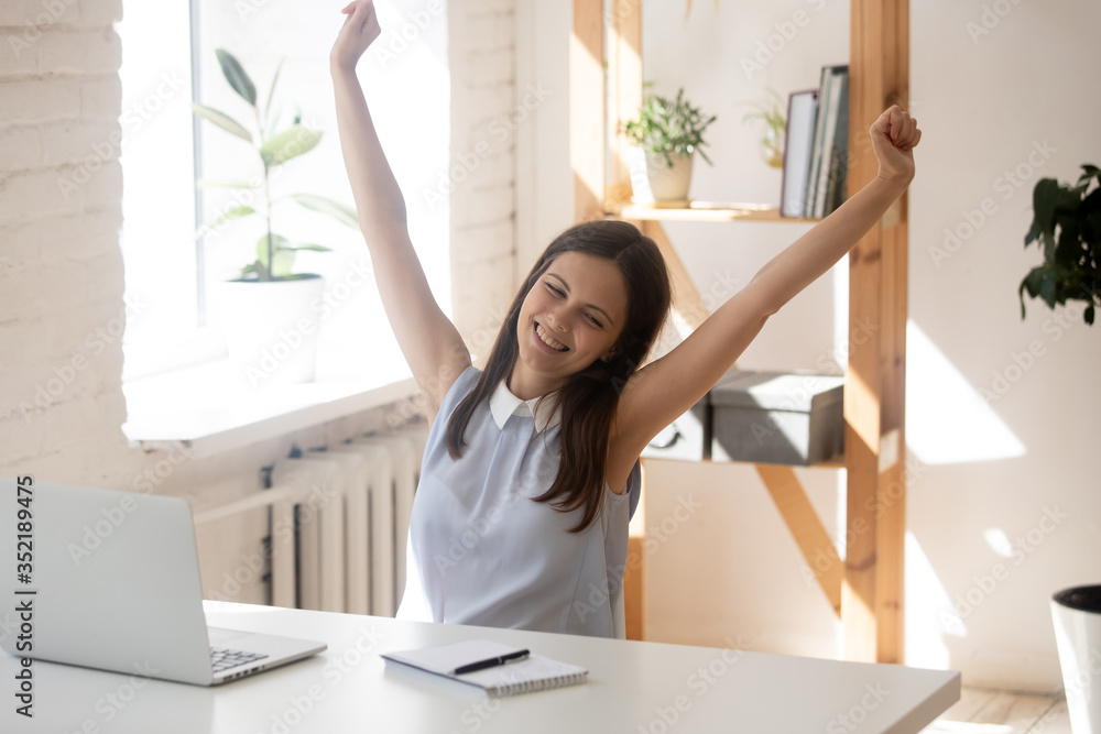 Happy female worker stretch exercise at workplace after working day ...