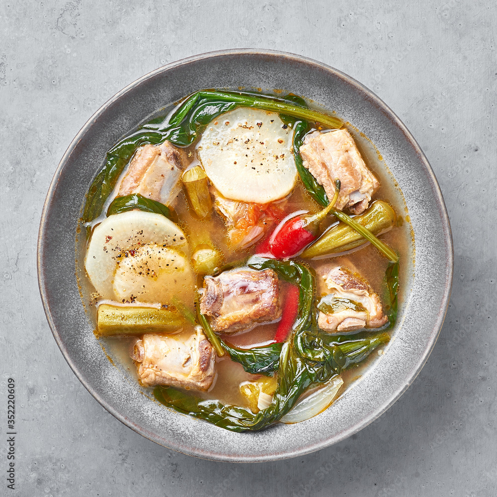 Sinigang na Baboy or Filipino Pork Meat Soup in gray bowl on concrete ...