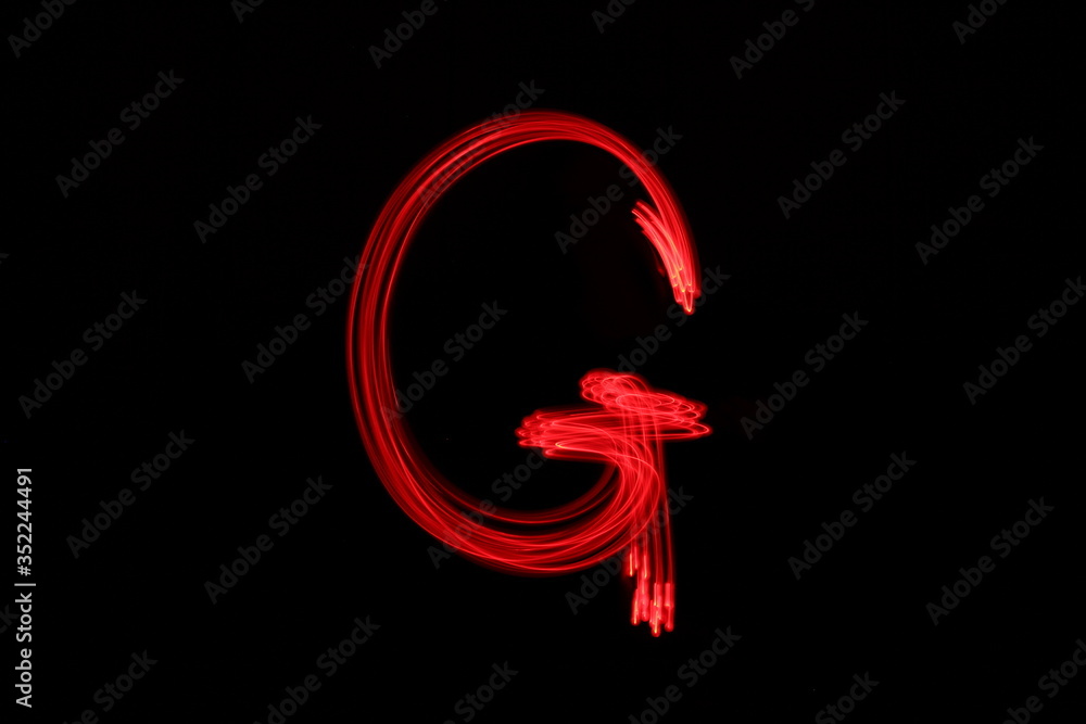 Long exposure photograph of the letter g in neon red colour fairy ...