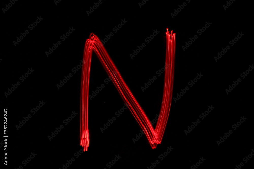 Long exposure photograph of the letter n in neon red colour fairy ...